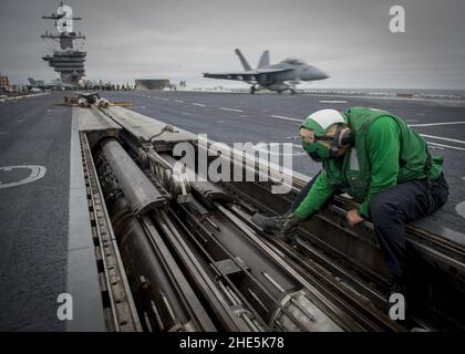 A Sailor performs maintenance on a catapult aboard a U.S. Navy ship ...