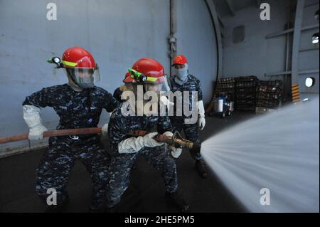 Sailors practice fire hose handling. (8283345597 Stock Photo - Alamy