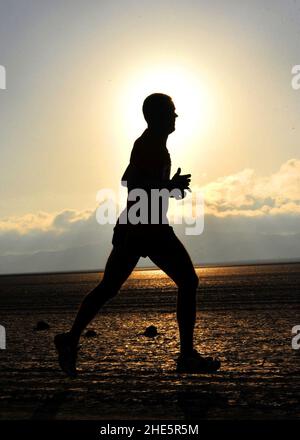 Sailors run through desert Stock Photo - Alamy