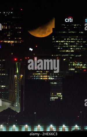 A waxing crescent moon sets behind the Statue Of Liberty on Tuesday ...