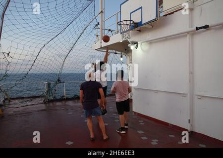 Crewmembers playing basketball on container merchant ship Stock Photo ...