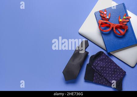 Laptop with party decor, necktie and socks on color background Stock ...