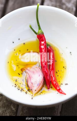 red chillies and olive oil in a jar of clay Stock Photo - Alamy