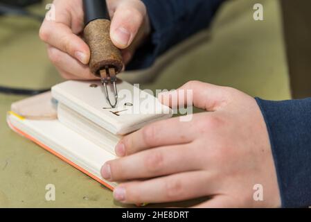 Poker work with tool - close up pyrography Stock Photo - Alamy