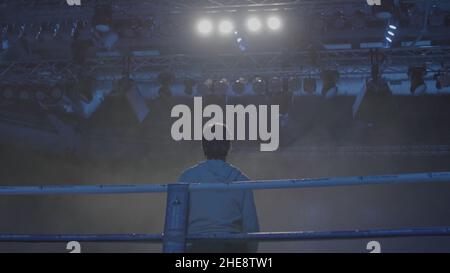 Back view of working gaffer or lighting technician and spotlights ...