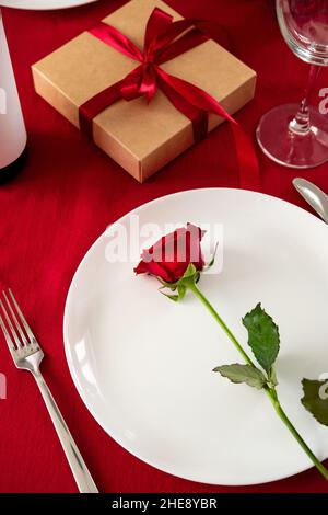 Plate with rose flower and ribbon on table. Valentine's Day celebration ...