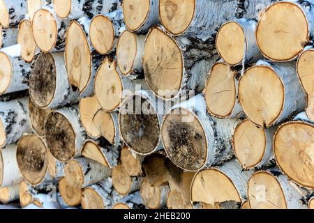 Wall of wooden chocks, firewood stacked together, old chopped brown and ...