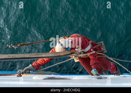 Seaman ship crew working aloft at height derusting and getting vessel ...