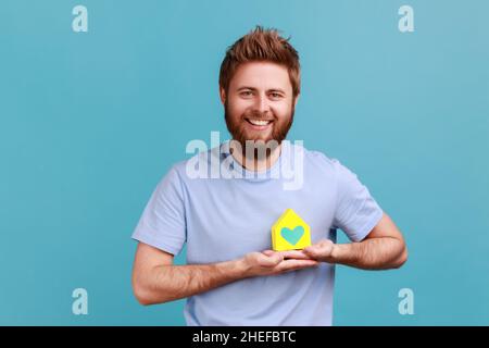 Young bearded man with paper heart for Valentine's Day on yellow ...
