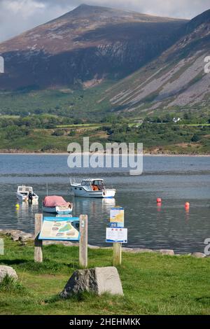 Boats moored in the shelter of Trefor Harbour behind an information ...