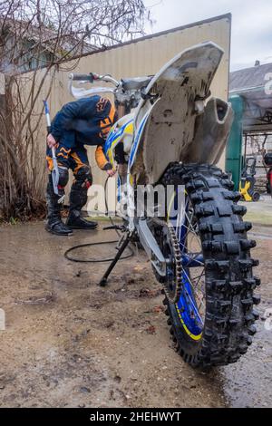 A man jet washing his bike at motocross track J4M54 during a break in ...