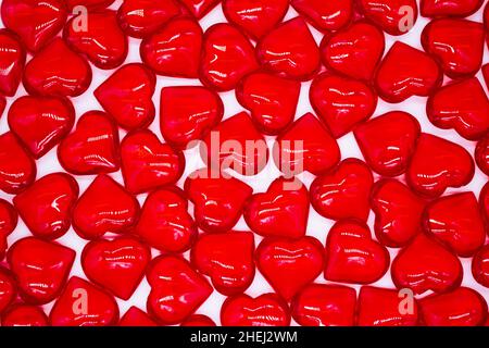 A large number of bright red hearts shiny, glass on a white background ...