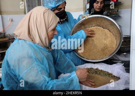 Palestinian women prepare "Maftoul", a traditional couscous dish made ...