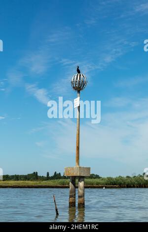 marker for the waterway at the lagoon in Venice under blue sky with ...