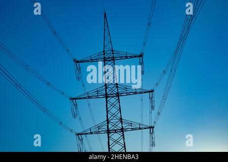 crossing electric pylon in sunset sky Stock Photo - Alamy
