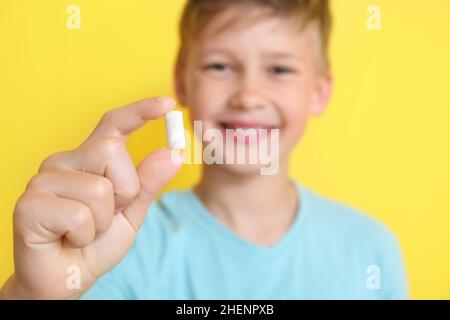 Little boy chewing gum on yellow background, closeup Stock Photo - Alamy