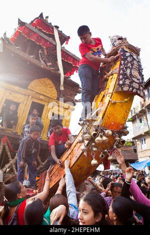 Residents hall a multi-tonne wooden chariot through the streets of ...