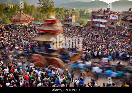 Residents hall a multi-tonne wooden chariot through the streets of ...
