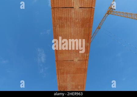 overthrow with red construction blocks under clear blue sky with crane ...