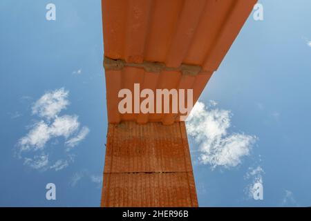 overthrow with red construction blocks under clear blue sky with crane ...