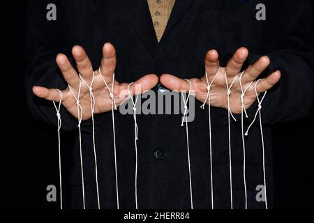 String-pulling puppeteer, studio photography with black background ...