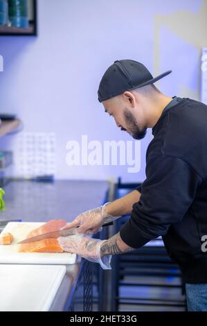 Sushi chef cutting fish and making sushi Stock Photo - Alamy