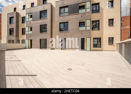 A terrace on the ground floor of a residential building with trees ...