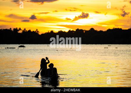 Family of native indigenous Orinoco tribe Warao swimming in traditional ...