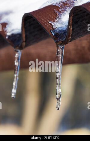 beautiful icicles shine in sun against blue sky. spring landscape with ...