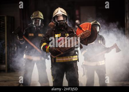 Group of professional firefighters wearing full equipment, oxygen masks ...