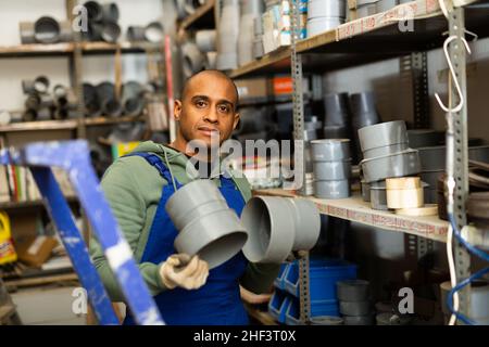 Latin american workman choosing supplies in shop of building materials ...