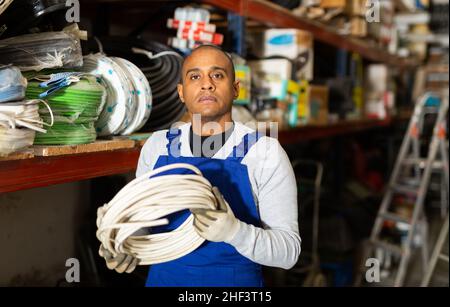 Latin american workman choosing supplies in shop of building materials ...