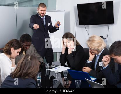 Angry boss berating his subordinates pointing out shortcomings and ...