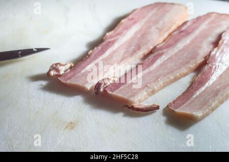 sliced bacon being fried in a skillet, selective focus Stock Photo - Alamy