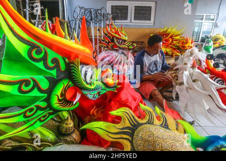 Bogor, Indonesia. 14th Jan, 2022. A worker create of lion and dragon dance costume ahead of ...