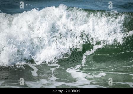 An angry turquoise green color massive rip curl of a wave as it rolls ...