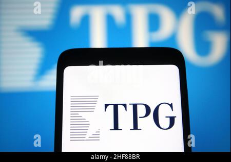 The TPG Capital logo is seen on an LED screen in the background while a ...