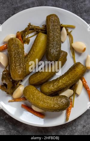 Plate of gherkins, pickled cucumbers on a white rustic wooden ...