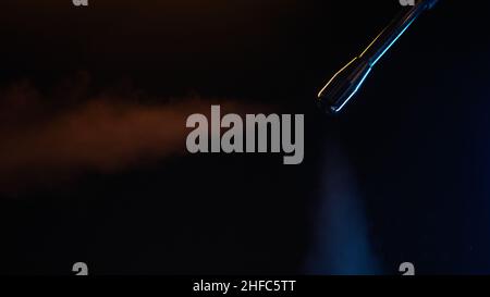 purging steam wand of coffee machine under neon lighting, wide photo ...