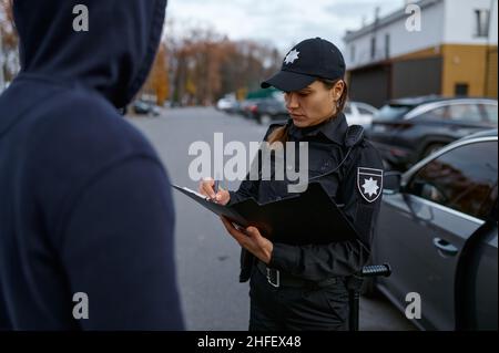 Police woman officer issuing fine to offender Stock Photo - Alamy