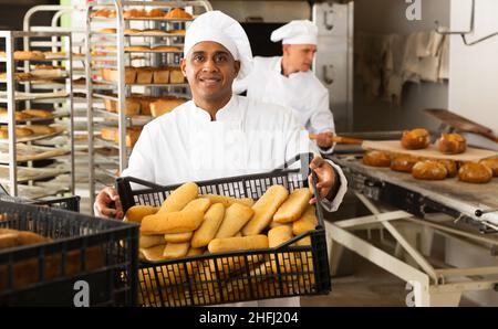 positive male baker with sesame bread in black box in kitchen Stock ...