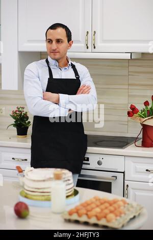 Master pastry chef in front of a desk. Cooking desserts at home. The ...