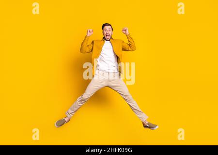 Full length photo of crazy lucky person raise fists triumph jumping ...