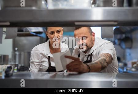 Chef taking order slip in commercial kitchen Stock Photo - Alamy