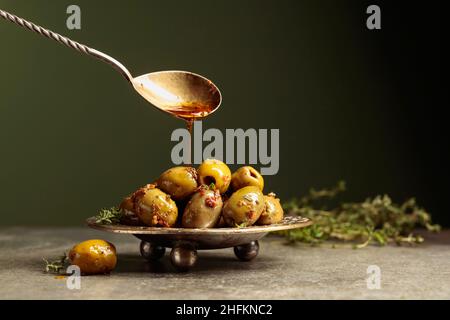 Spicy green olives are poured with olive oil with spices. Copy space ...