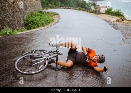 Exhausted cyclist fell down on the road Stock Photo - Alamy