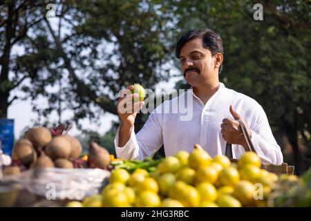 Man in white kurta shopping lemon in market Stock Photo - Alamy