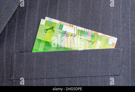 Banknotes of Norwegian krones sticking out of the business suit pocket ...