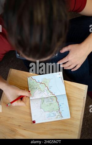 Person planning a trip with a map and a guidebook Stock Photo - Alamy