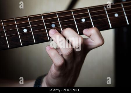 Hands hold the neck of the guitar, play it Stock Photo - Alamy